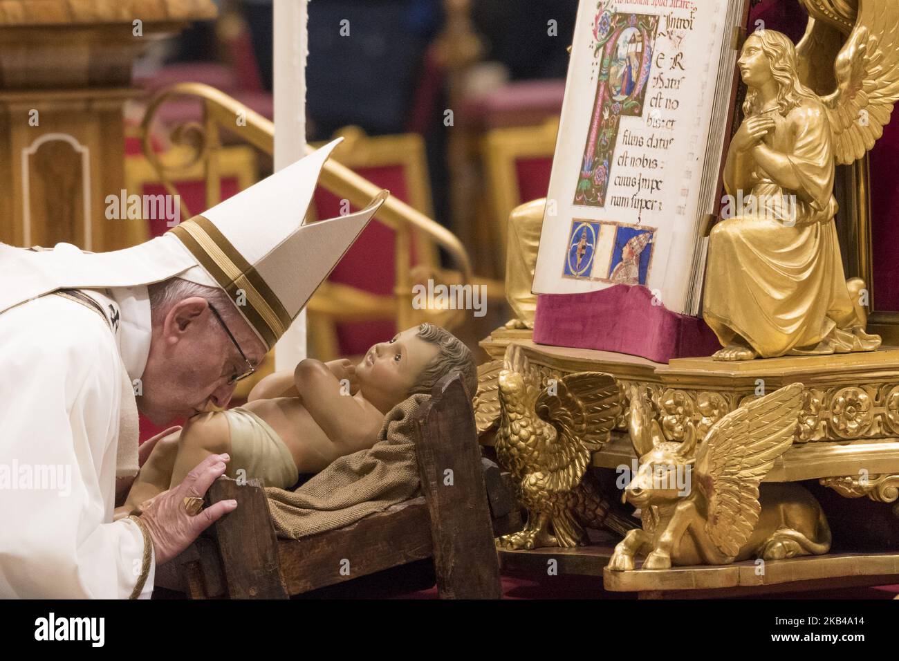 Pope Francis kisses a statue of Baby Jesus as he celebrates the ...