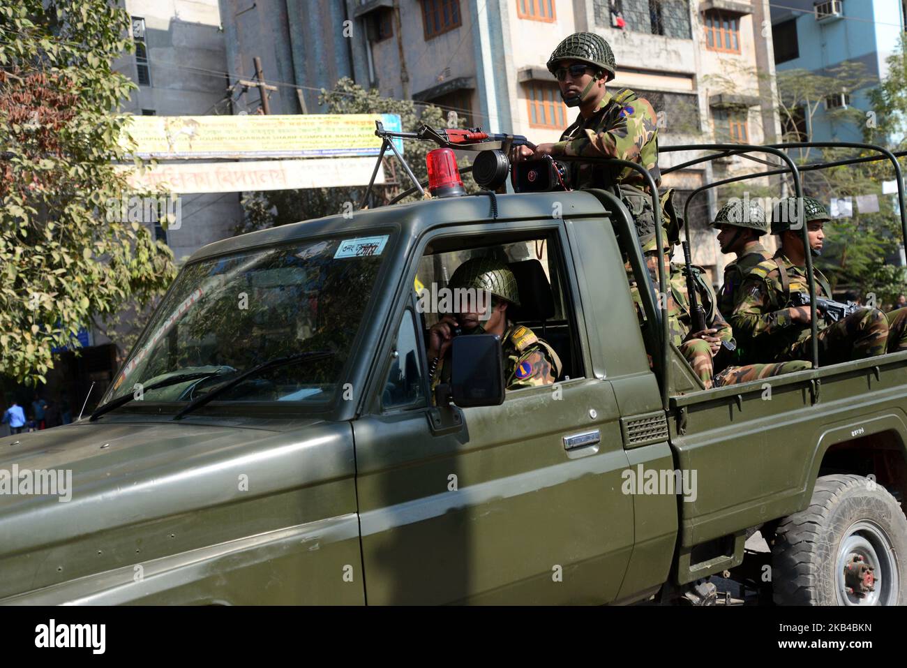 Bangladeshi army personnel drive a military vehicle through a street ...