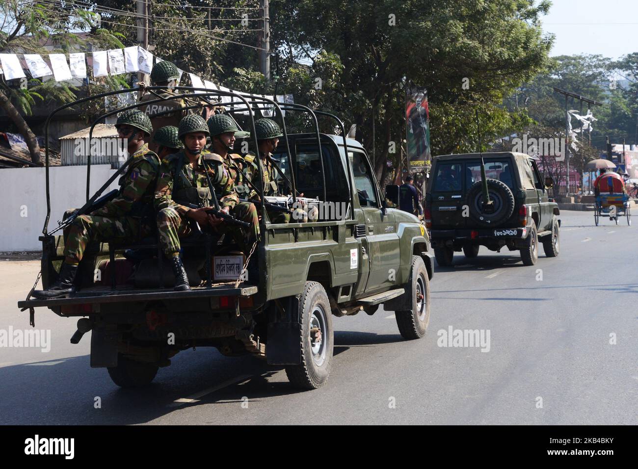 Bangladeshi army personnel drive a military vehicle through a street ...