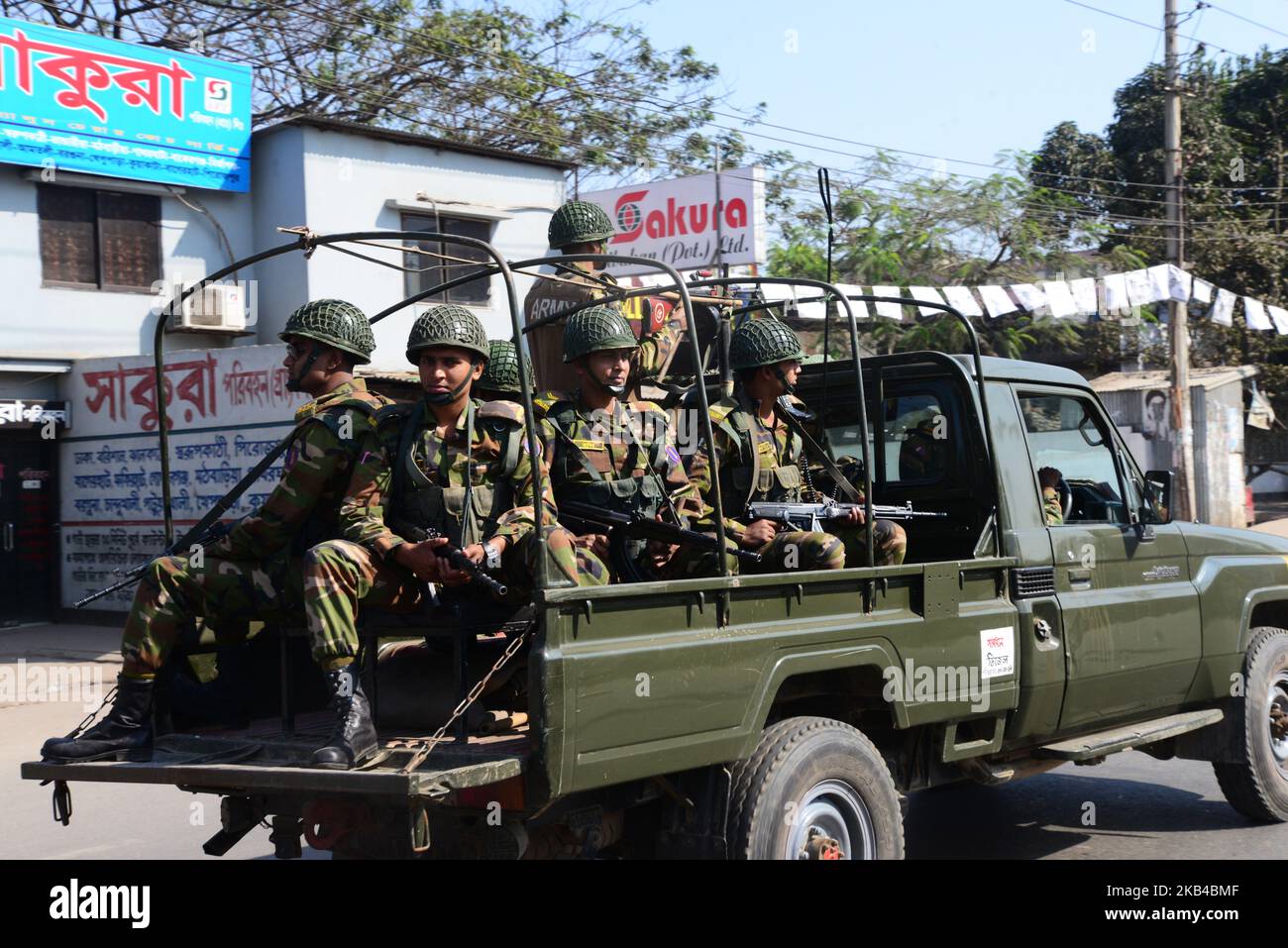 Bangladeshi army personnel drive a military vehicle through a street ...