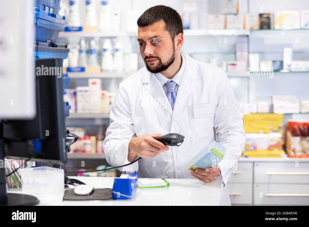 Male pharmacist scans the barcode of product at the checkout in ...