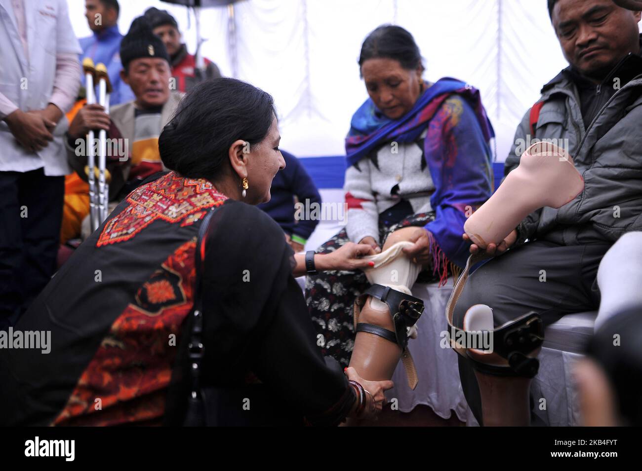 Dignitaries present artificial limbs to beneficiaries during Artificial ...