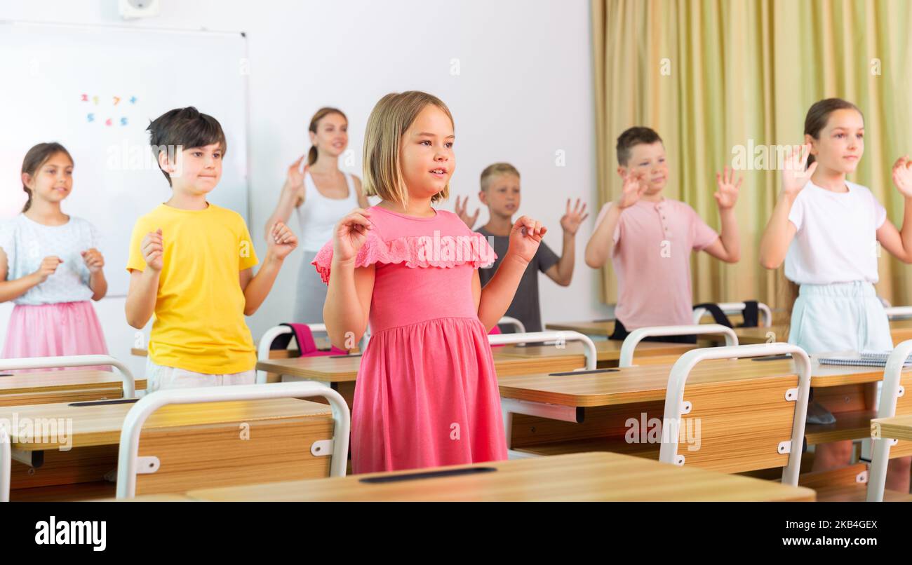 Small school kids doing physical exercises with teacher Stock Photo - Alamy