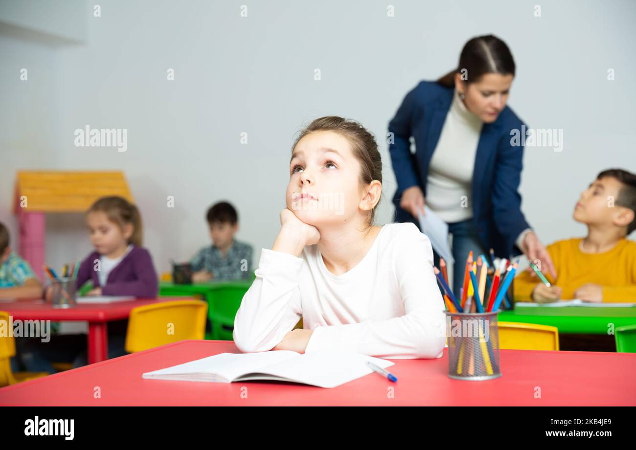 Tired schoolgirl at pupils desk at lesson Stock Photo - Alamy