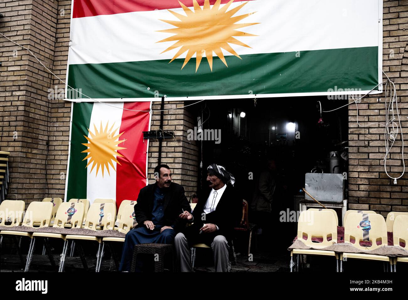 Men chatting surrounded by Kurdish flag in Irbil city center On December 2018, A trip inside ...