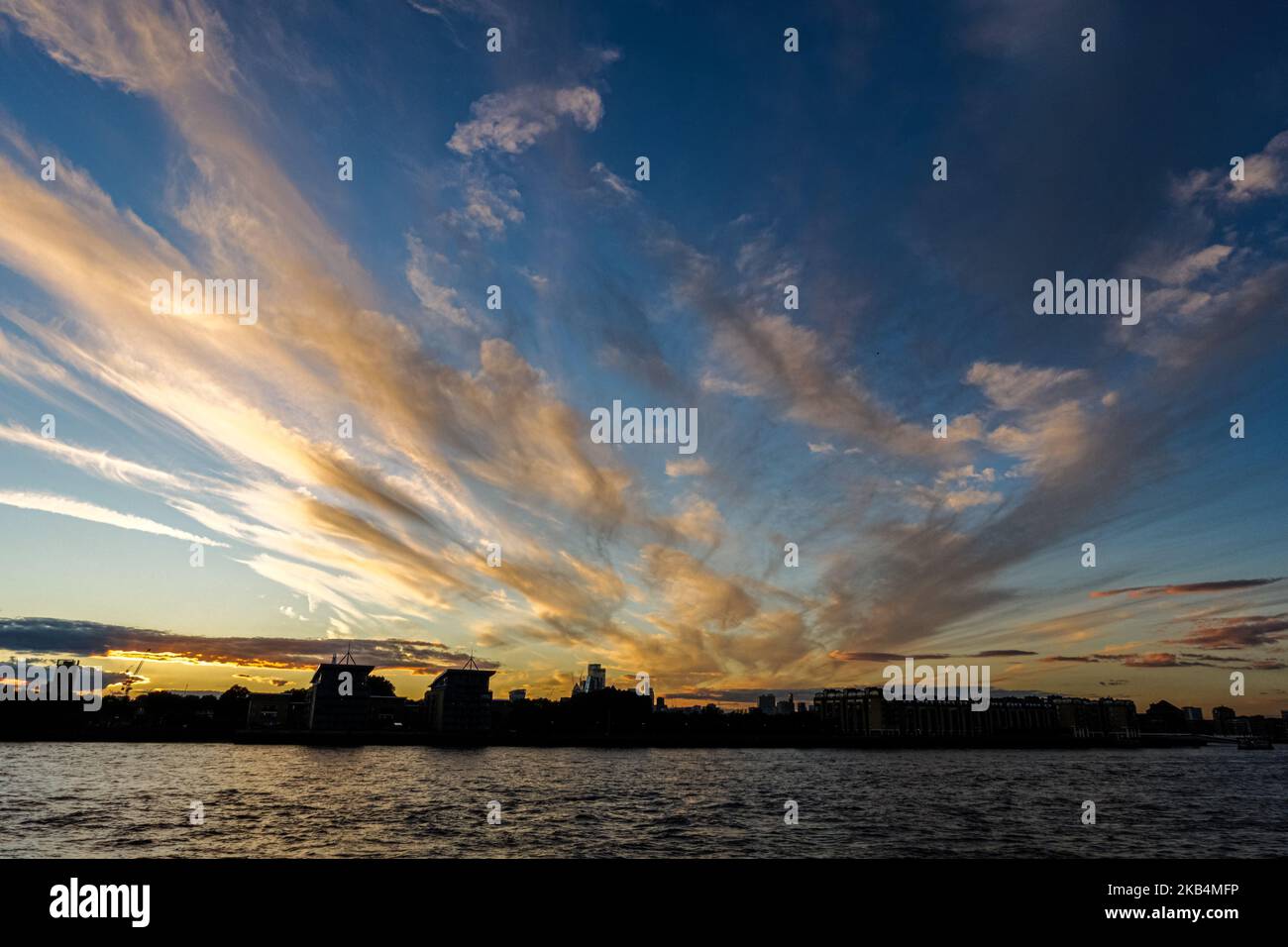 Sunset sky over a silhouette of city buildings Stock Photo - Alamy