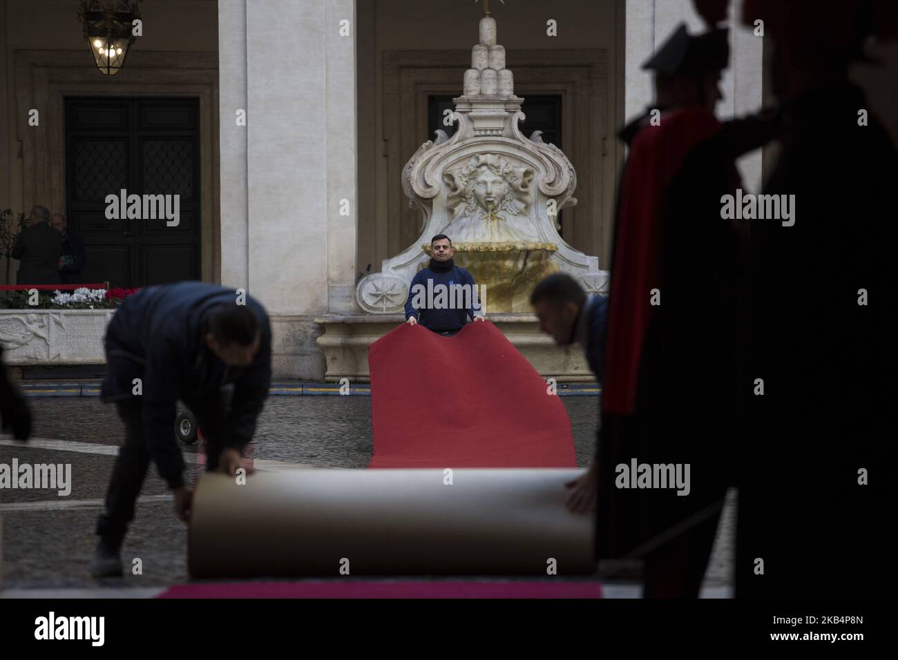 workers stretch out the red carpet before Italian Premier Giuseppe ...