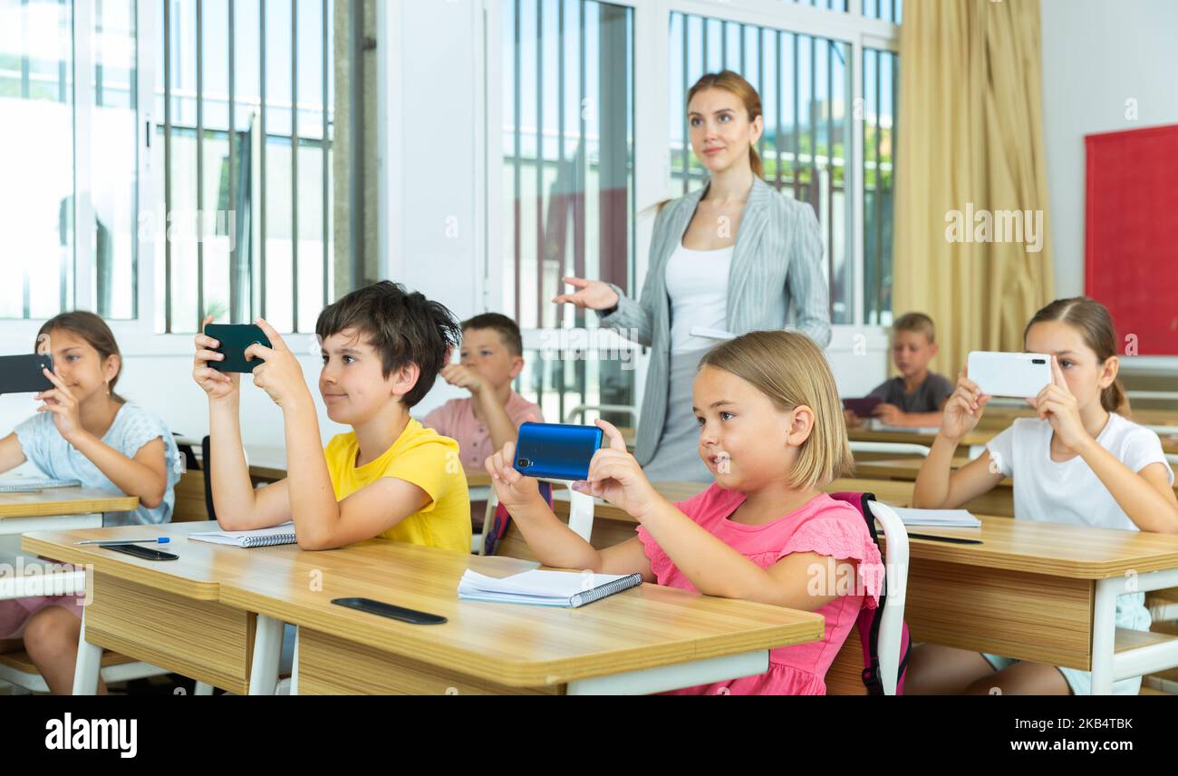 Pupils using mobile phones during lesson in school Stock Photo - Alamy