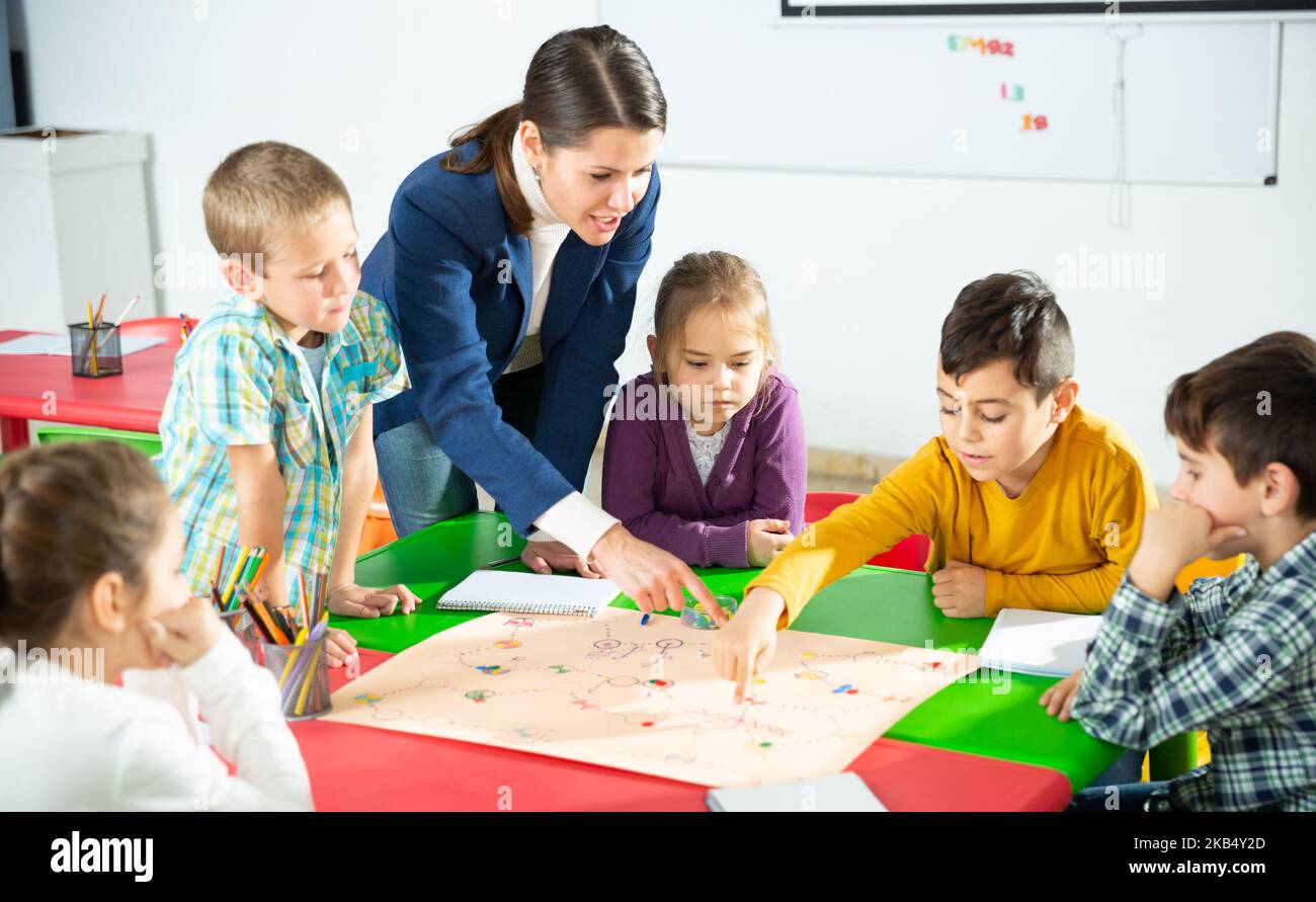 Kids and teacher playing educational board game Stock Photo - Alamy