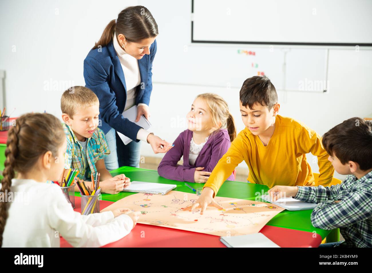 Teacher and pupils play a table game in elementary school class Stock ...