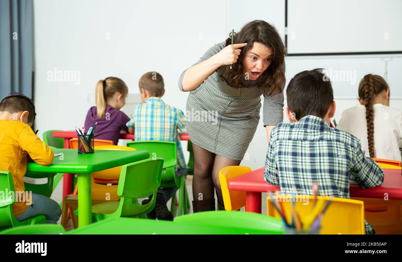 Female teacher scolding guilty student in elementary school class Stock ...