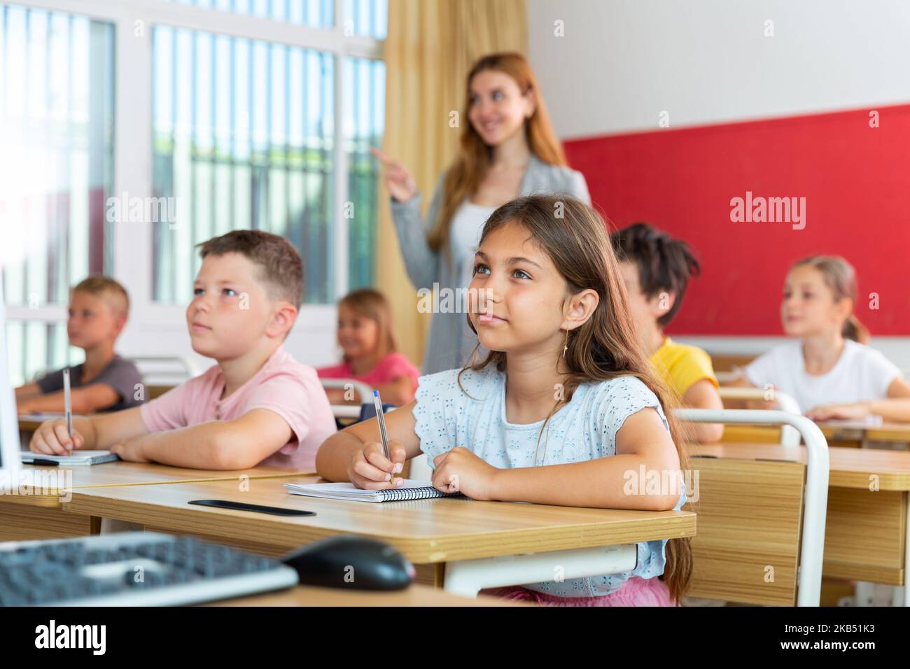 Schoolgirl sitting in classroom during lesson in elementary school ...