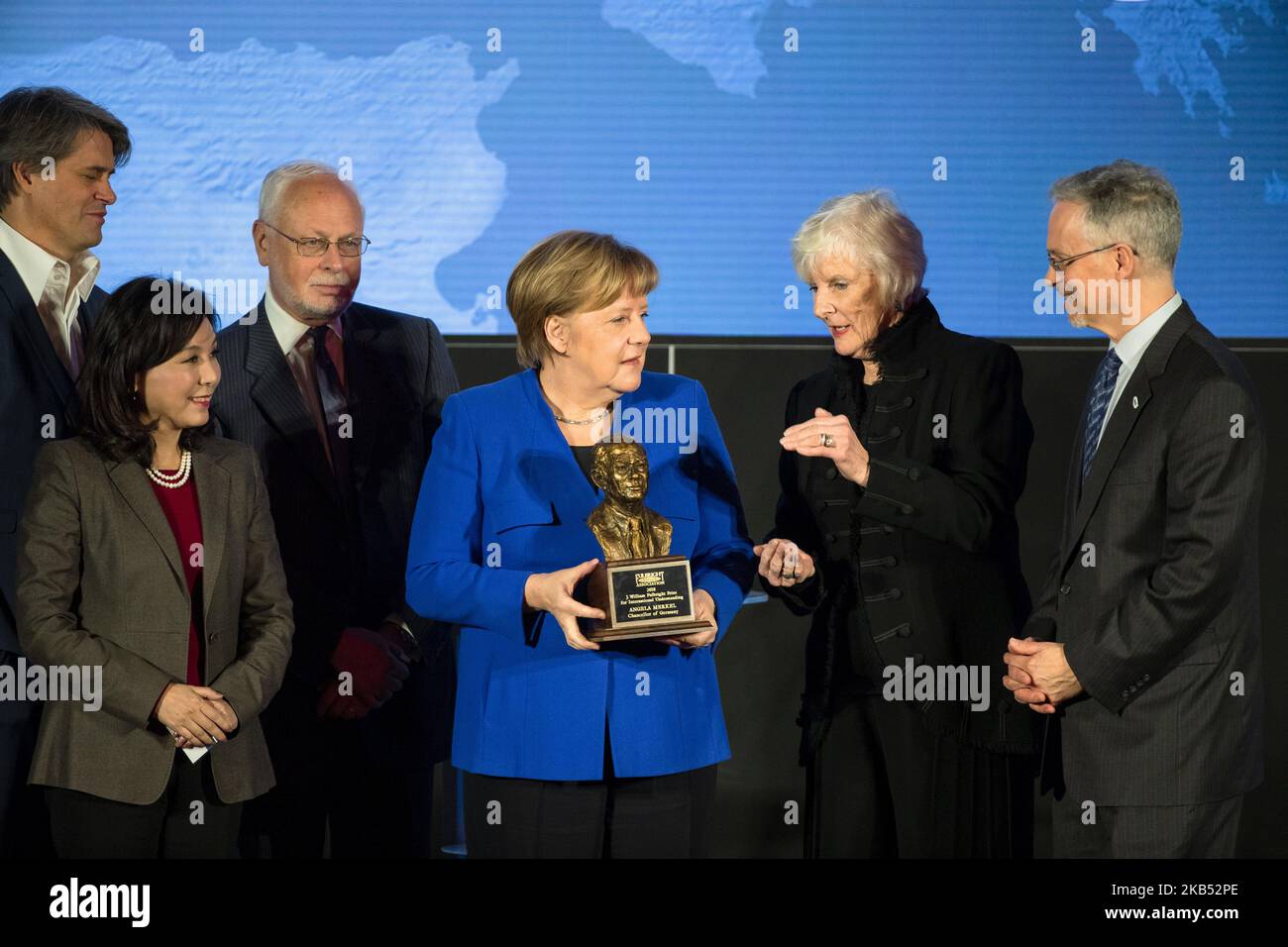 German Chancellor Angela Merkel (C) poses for a picture holding the ...