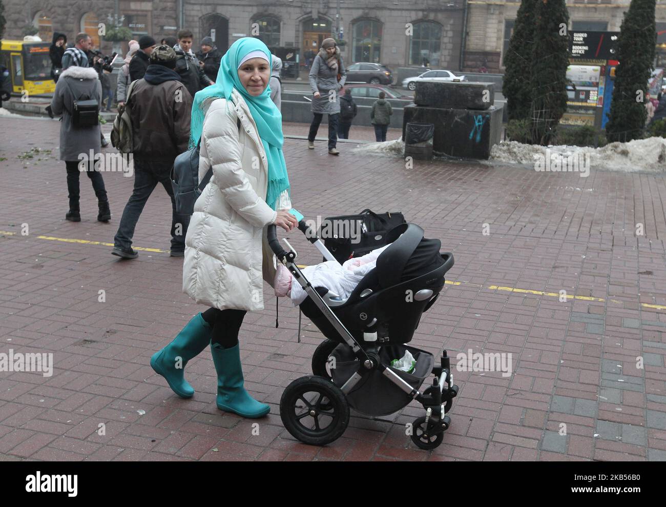 An Ukrainian muslim woman wearing hijab with a baby carriage attends a ...