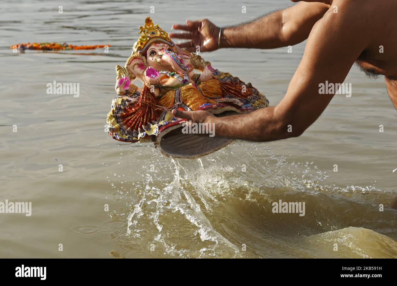 A devotee carries an idol of elephant-headed Hindu god Ganesha, for ...
