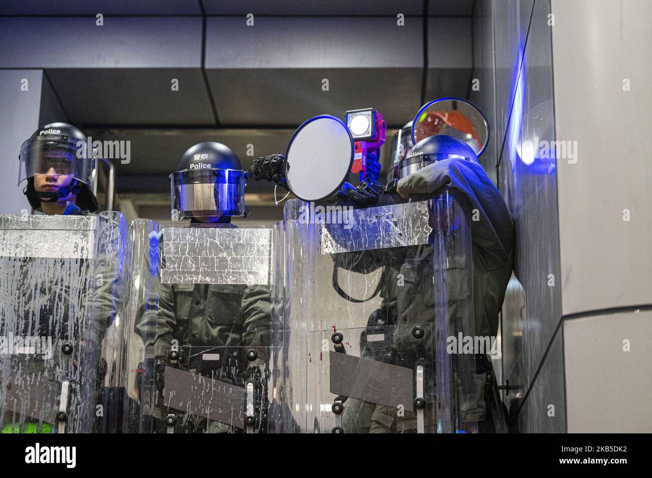 Riot police are seen holding up mirrors in a police station in Hong ...