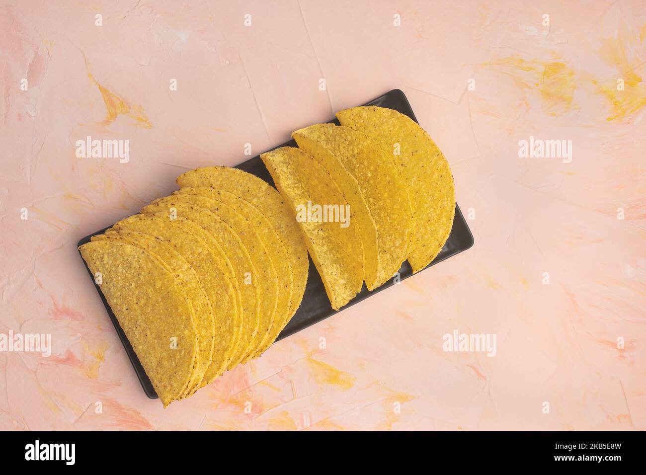 Empty taco shells ingredient. Mexican corn tortilla on black serving ...