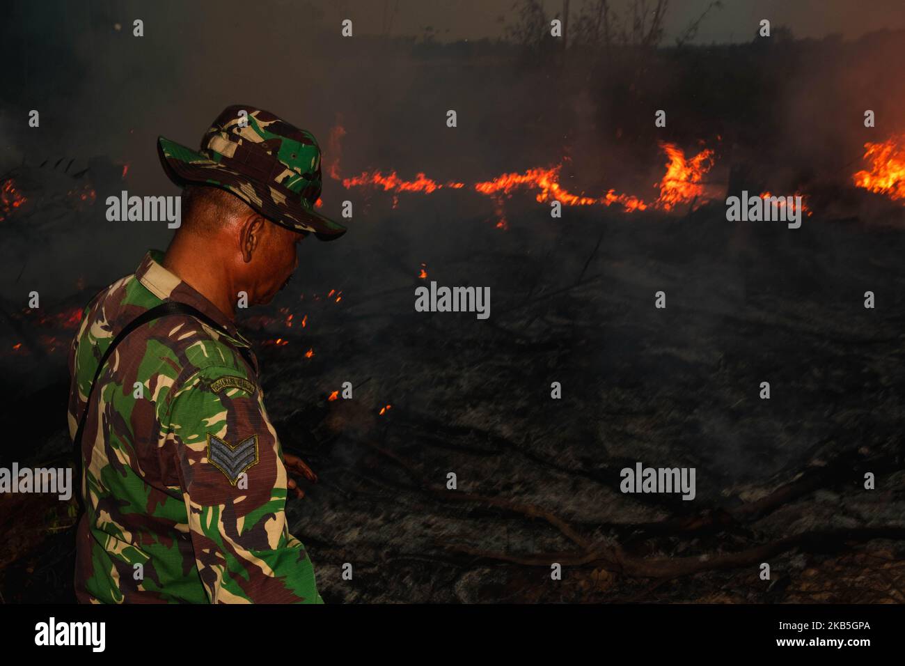 An Indonesian firefighter tries to extinguish peatland fire at Tanah ...