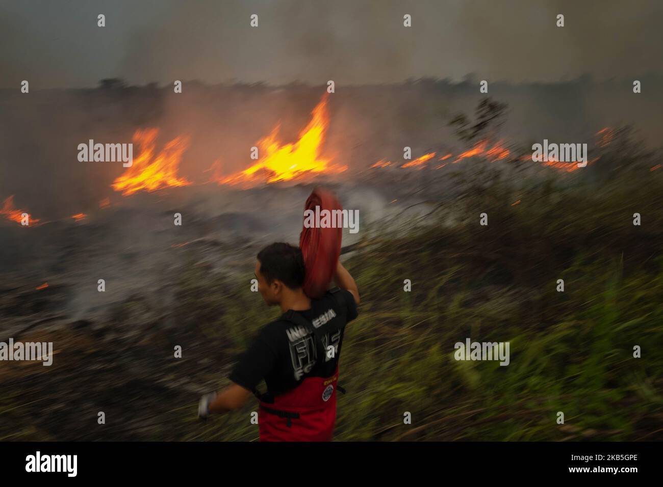 An Indonesian firefighter tries to extinguish peatland fire at Tanah ...