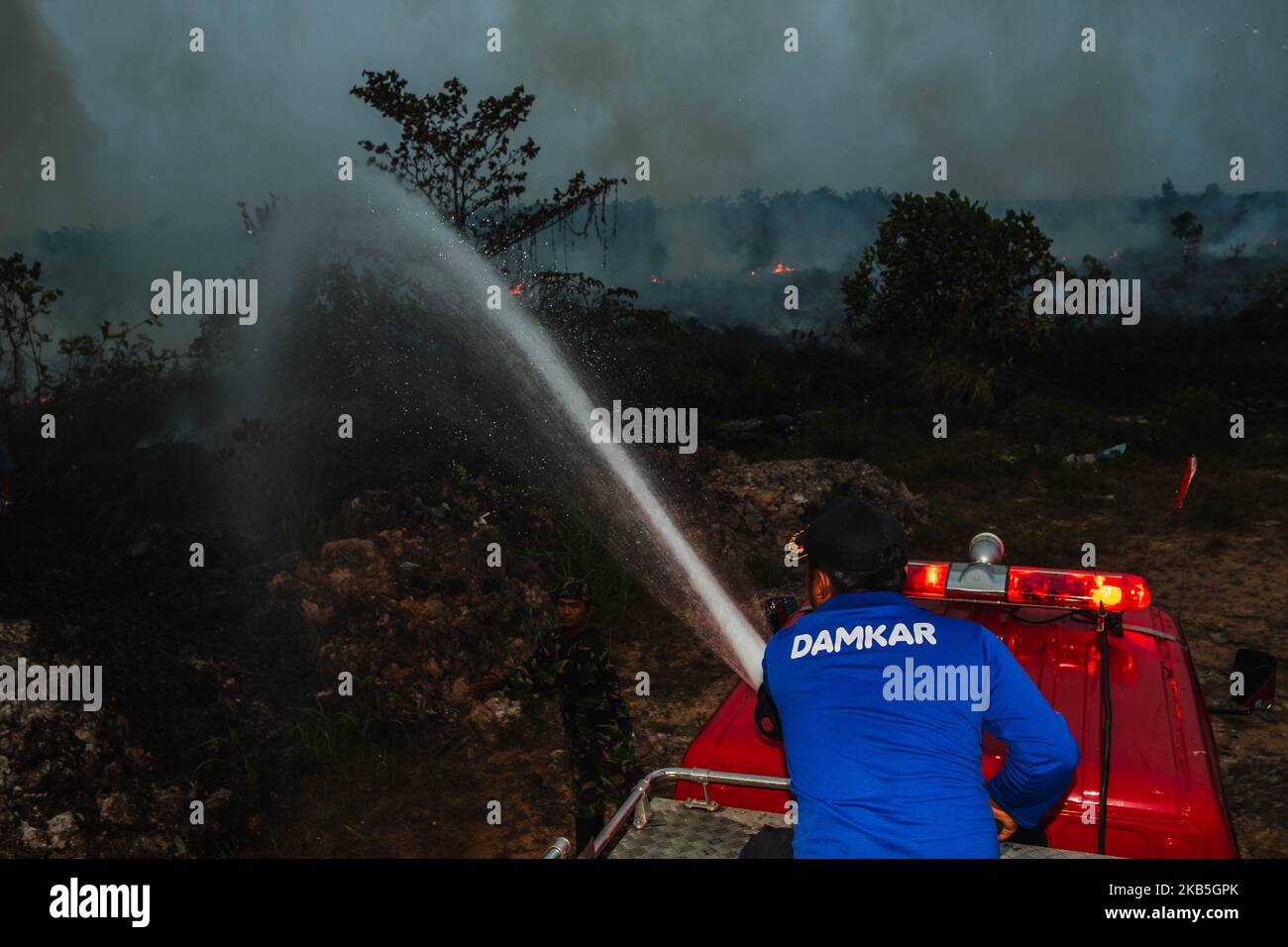 An Indonesian firefighter tries to extinguish peatland fire at Tanah ...