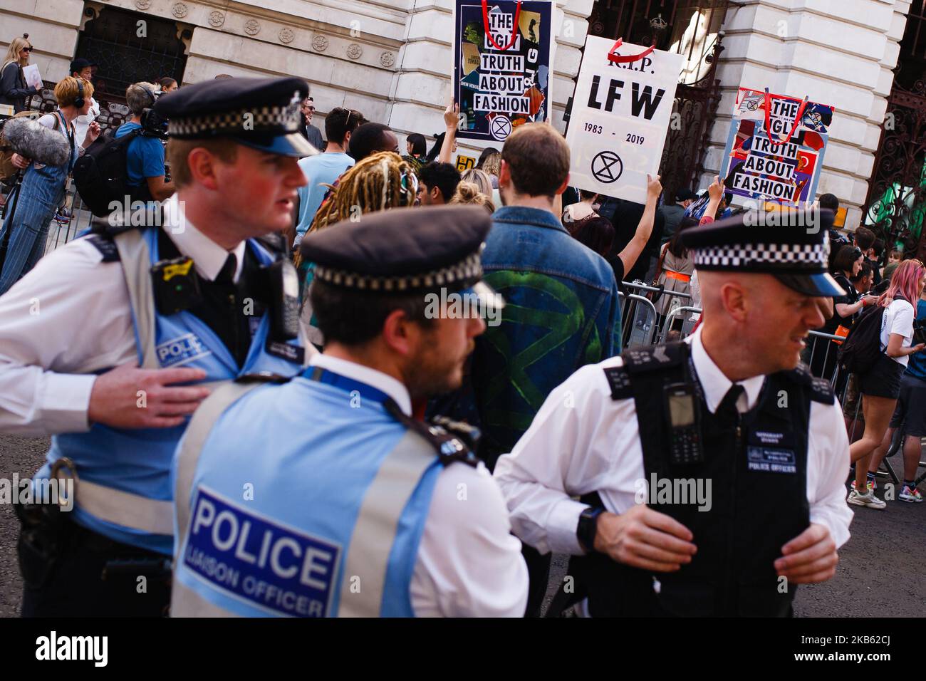 Police officers look on as members of climate change activist group ...