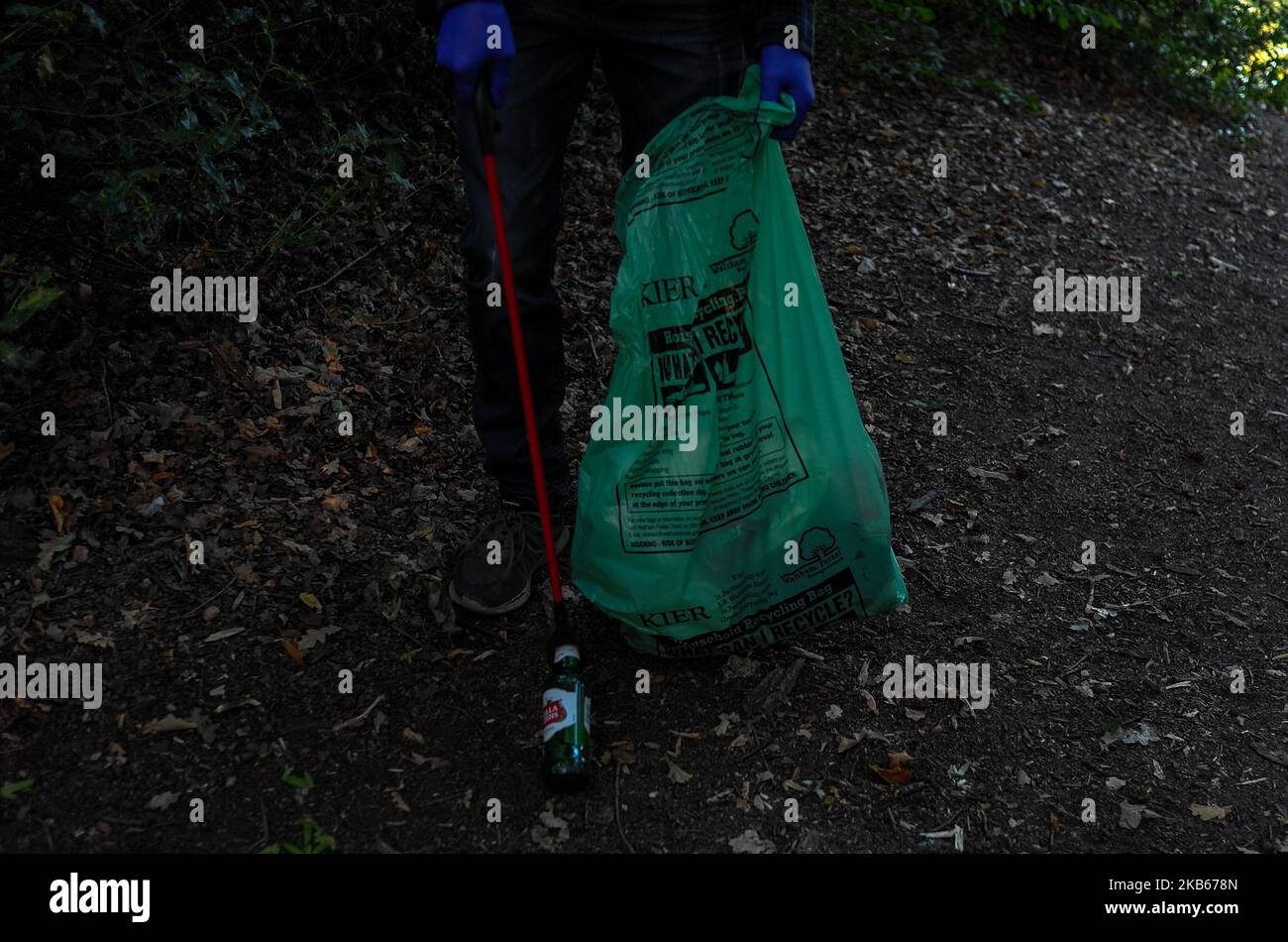 An environment volunteer walks in the Epping Forest, with a litter back ...