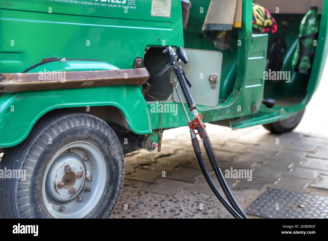 An employee fills up a customer's auto with compressed natural gas (CNG ...