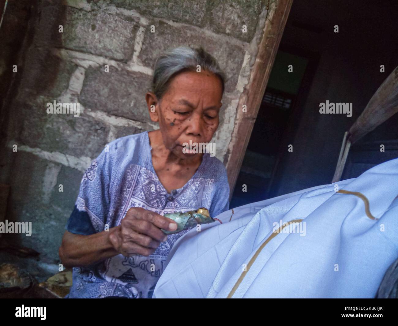 A woman batik artist creating various designs drawing with a pen-like ...