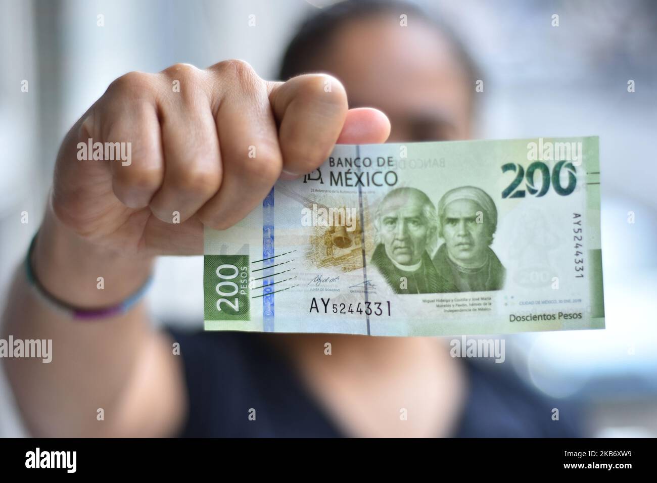 A girl holds the new model of 200 Mexican peso bill that are already in ...