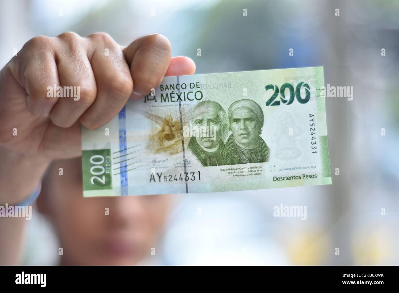 A girl holds the new model of 200 Mexican peso bill that are already in ...
