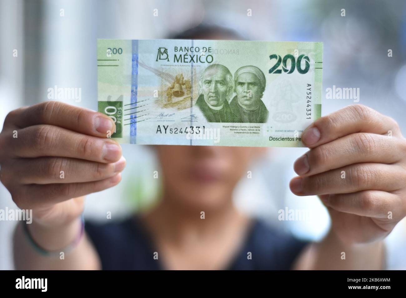 A Girl Holds The New Model Of 200 Mexican Peso Bill That Are Already In a-girl-holds-the-new-model-of-200-mexican-peso-bill-that-are-already-in