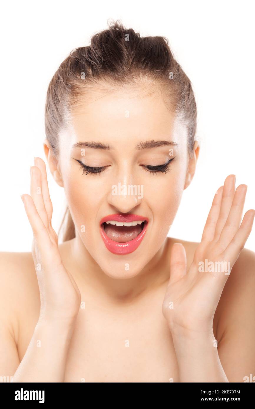 Beautiful girl studio portrait. Making hand gestures and face expressions against white ...