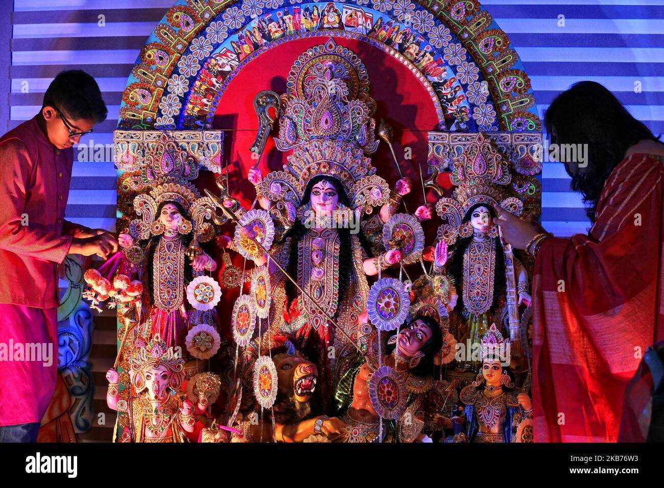 Devotees decorate the idol the Goddess Durga before prayers commence ...