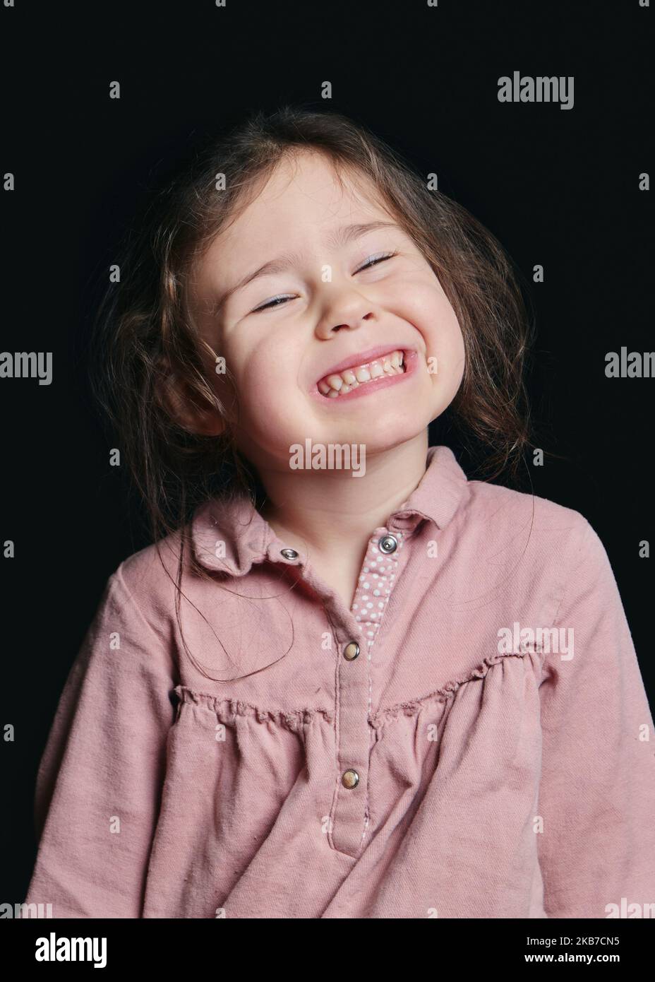 cute girl making expressive faces in the studio against a black ...