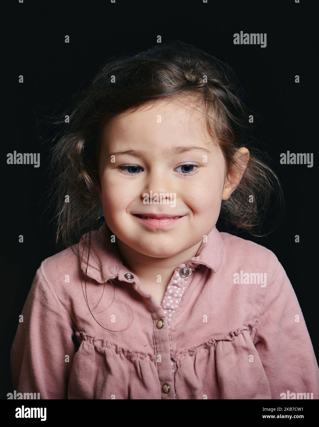 cute girl making expressive faces in the studio against a black ...