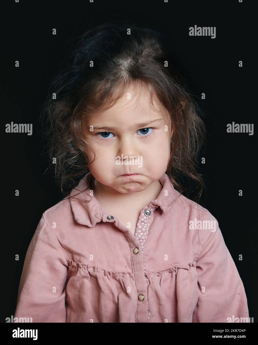 cute girl making expressive faces in the studio against a black ...