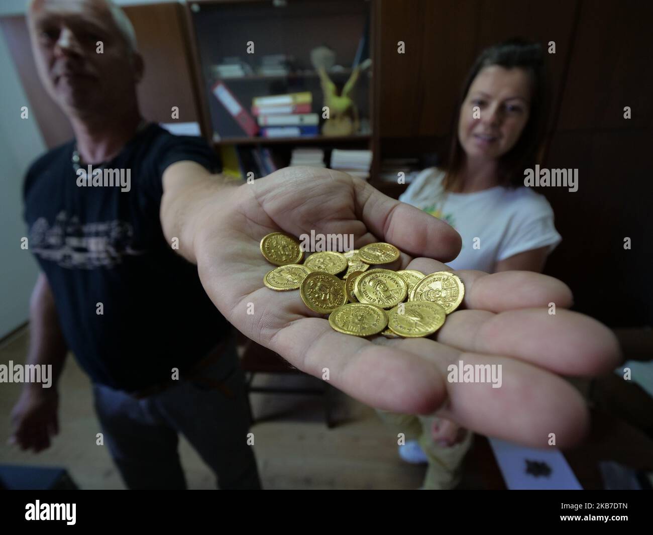 The archaeologist Hristo Kuzov shows golden coins, discovered during ...