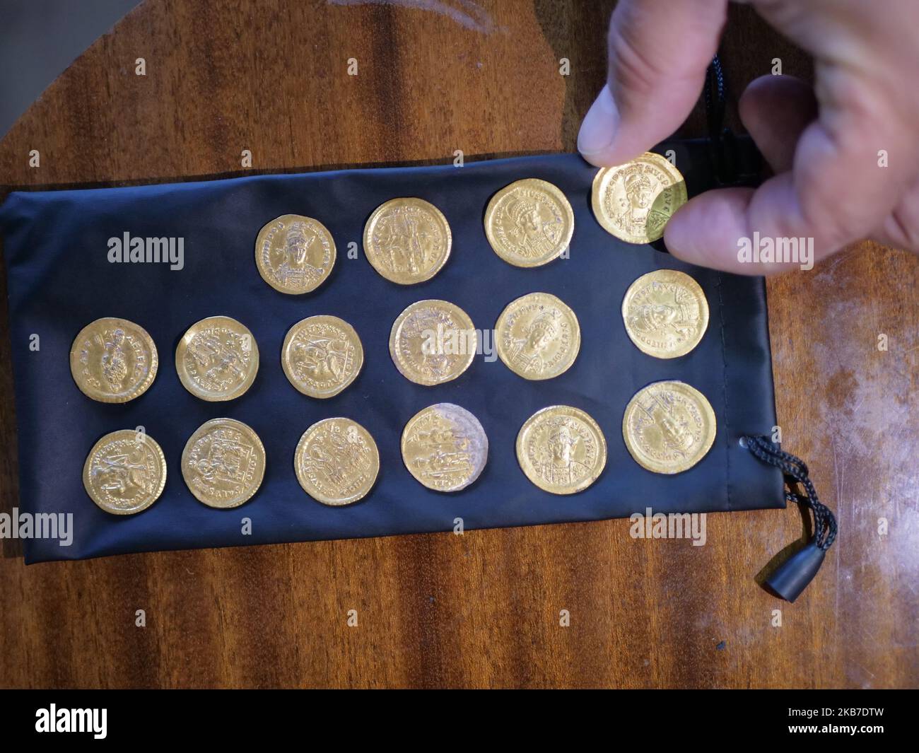 The archaeologist Hristo Kuzov shows golden coins, discovered during ...