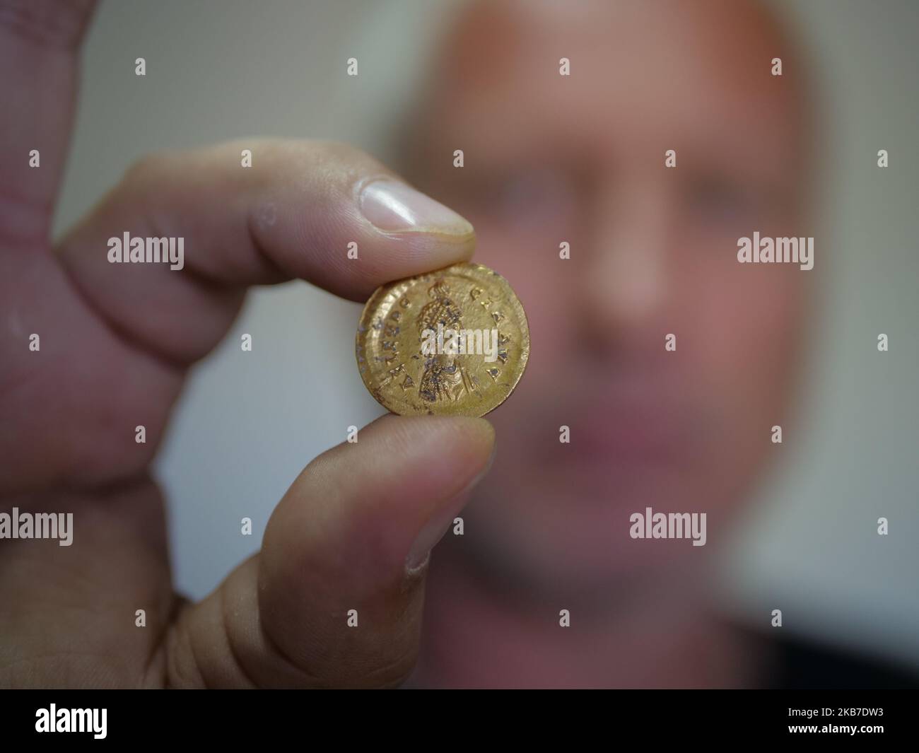 The archaeologist Hristo Kuzov shows golden coins, discovered during ...