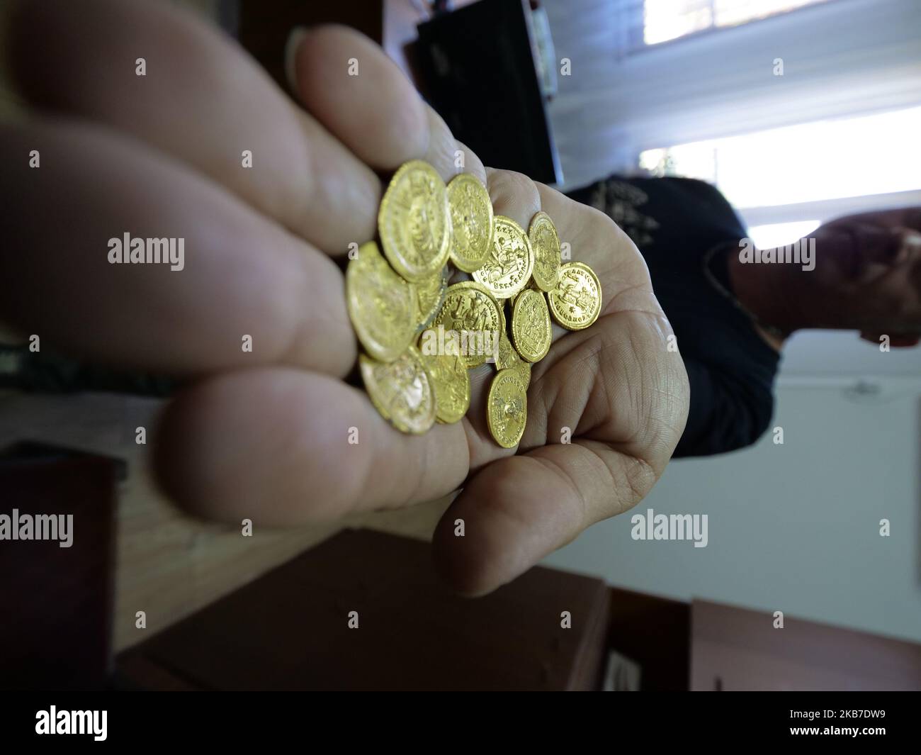 The archaeologist Hristo Kuzov shows golden coins, discovered during ...