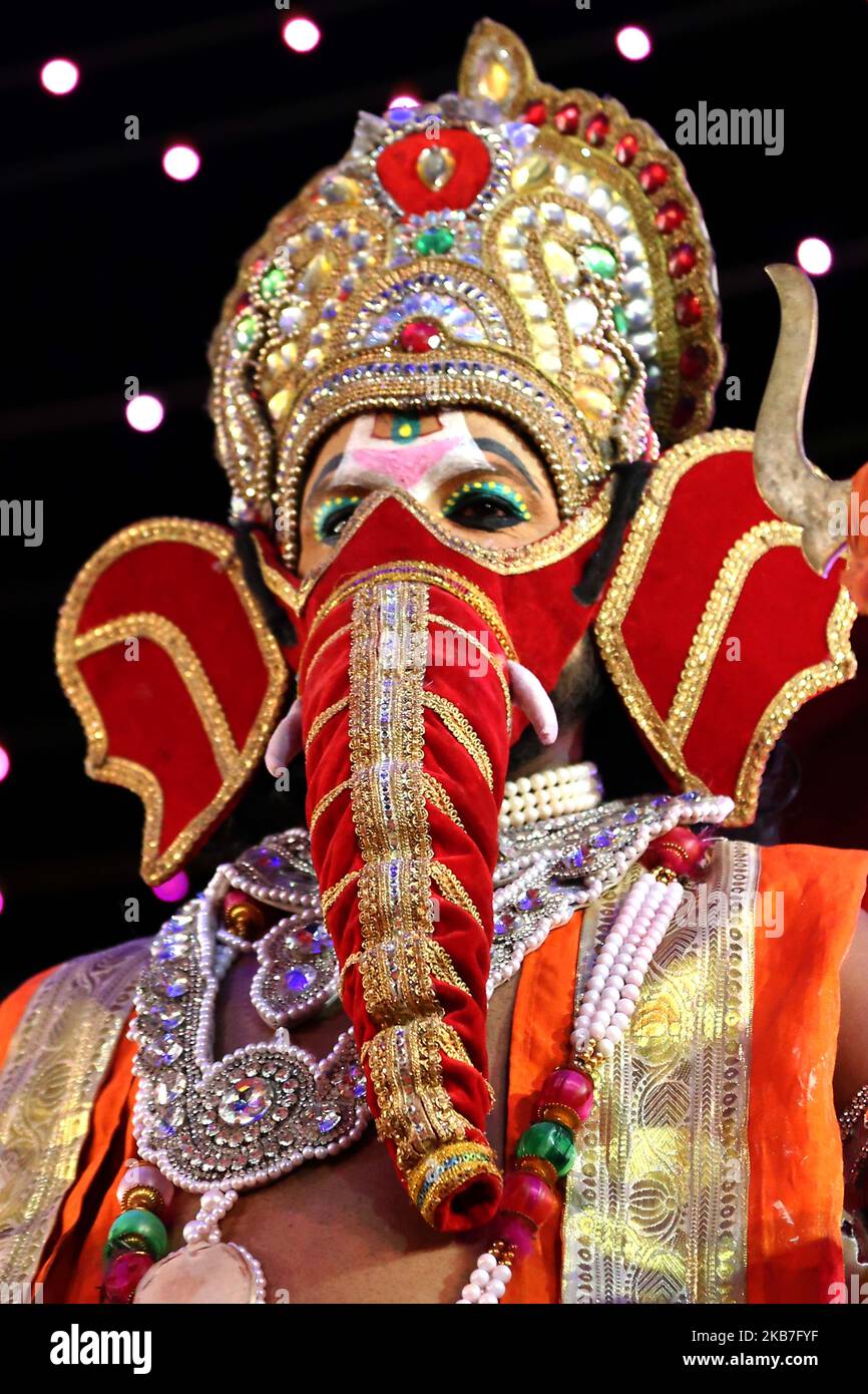 An Indian artist dressed as Hindu god Lord Ganesha performs during ...