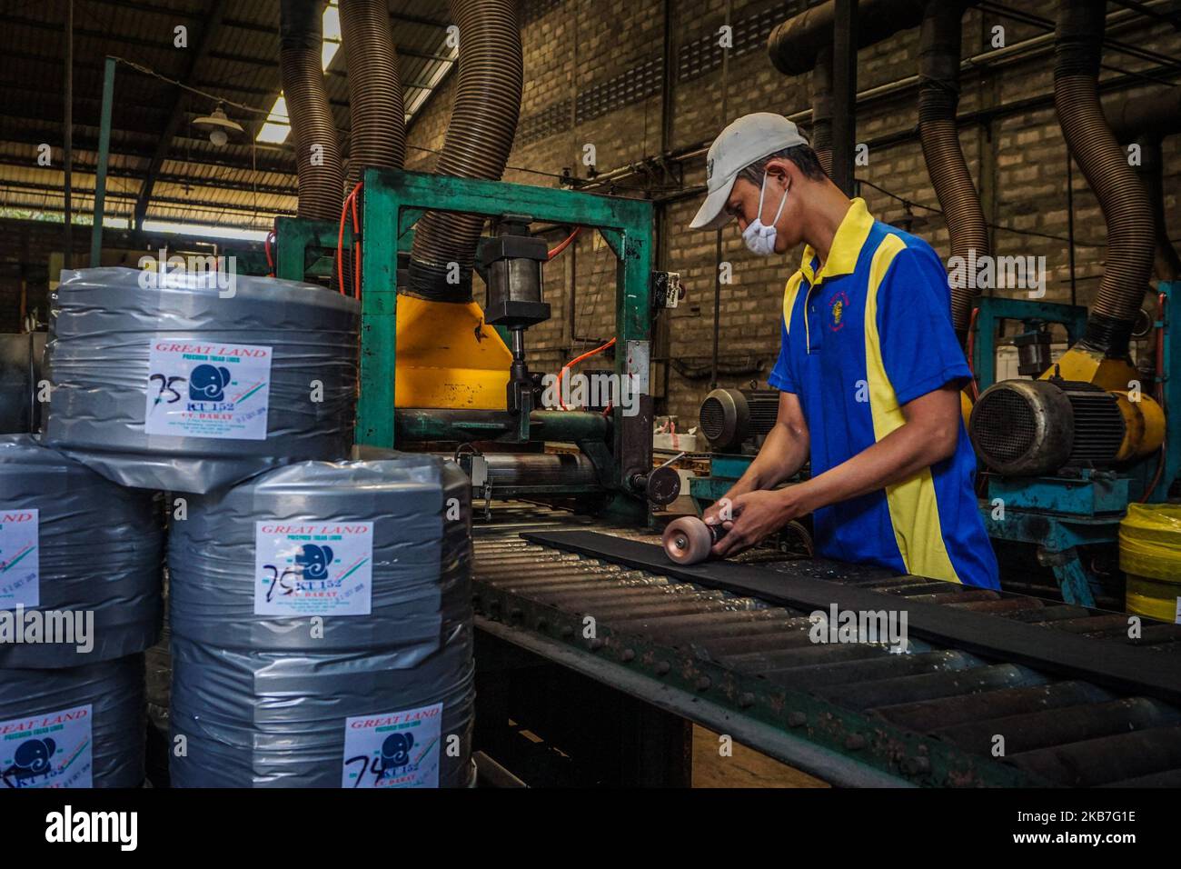 Workers produce retread tires using gas network energy from the PT ...