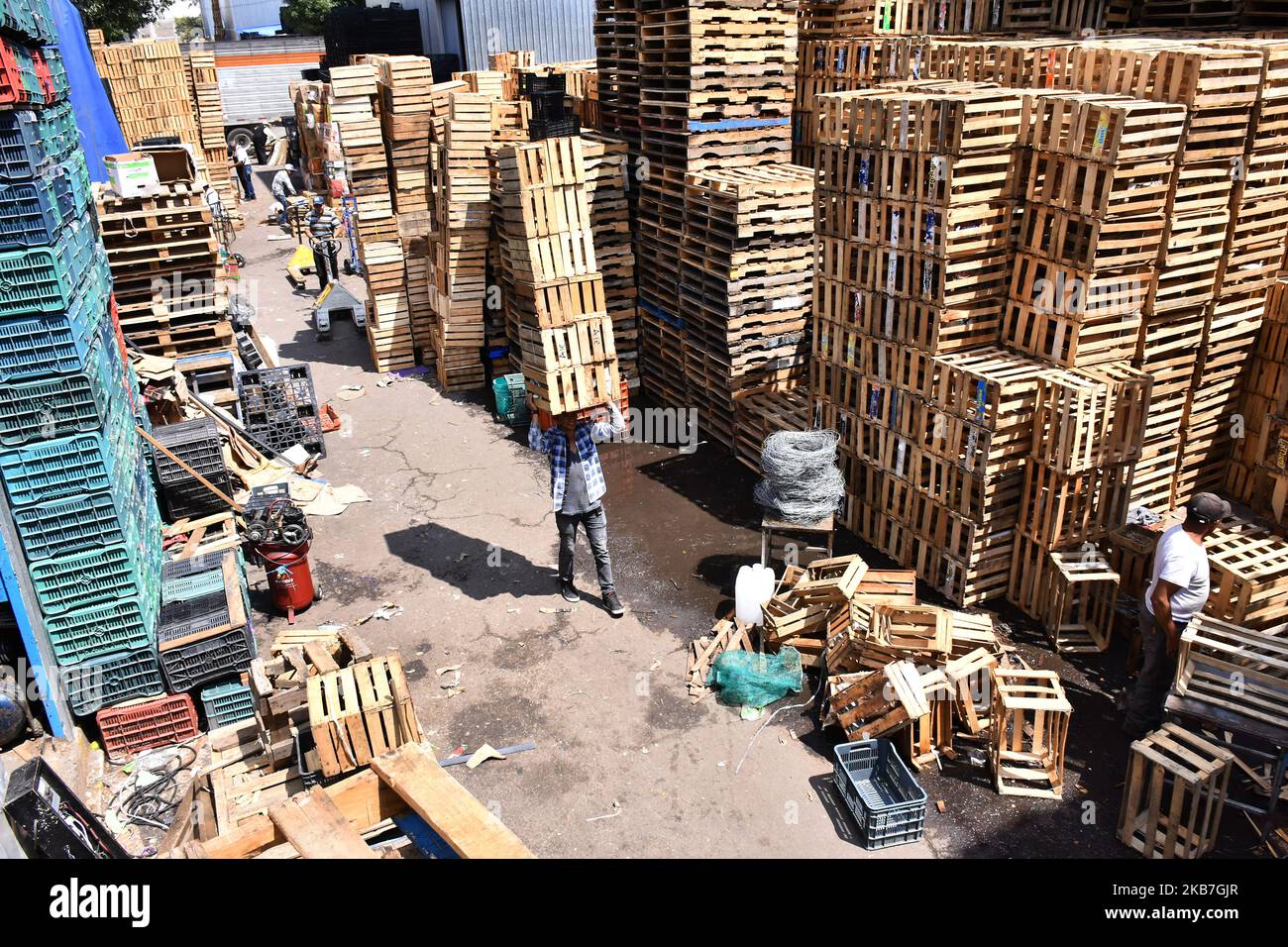 A man is seen working accommodating boxes of fruit and vegetables in ...