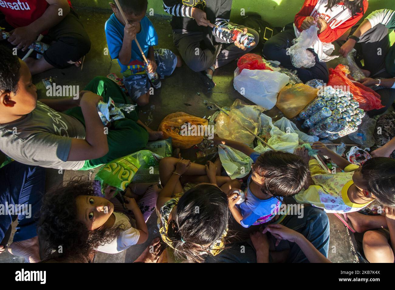 Children put plastic waste into bottles for decoration and crafts in ...