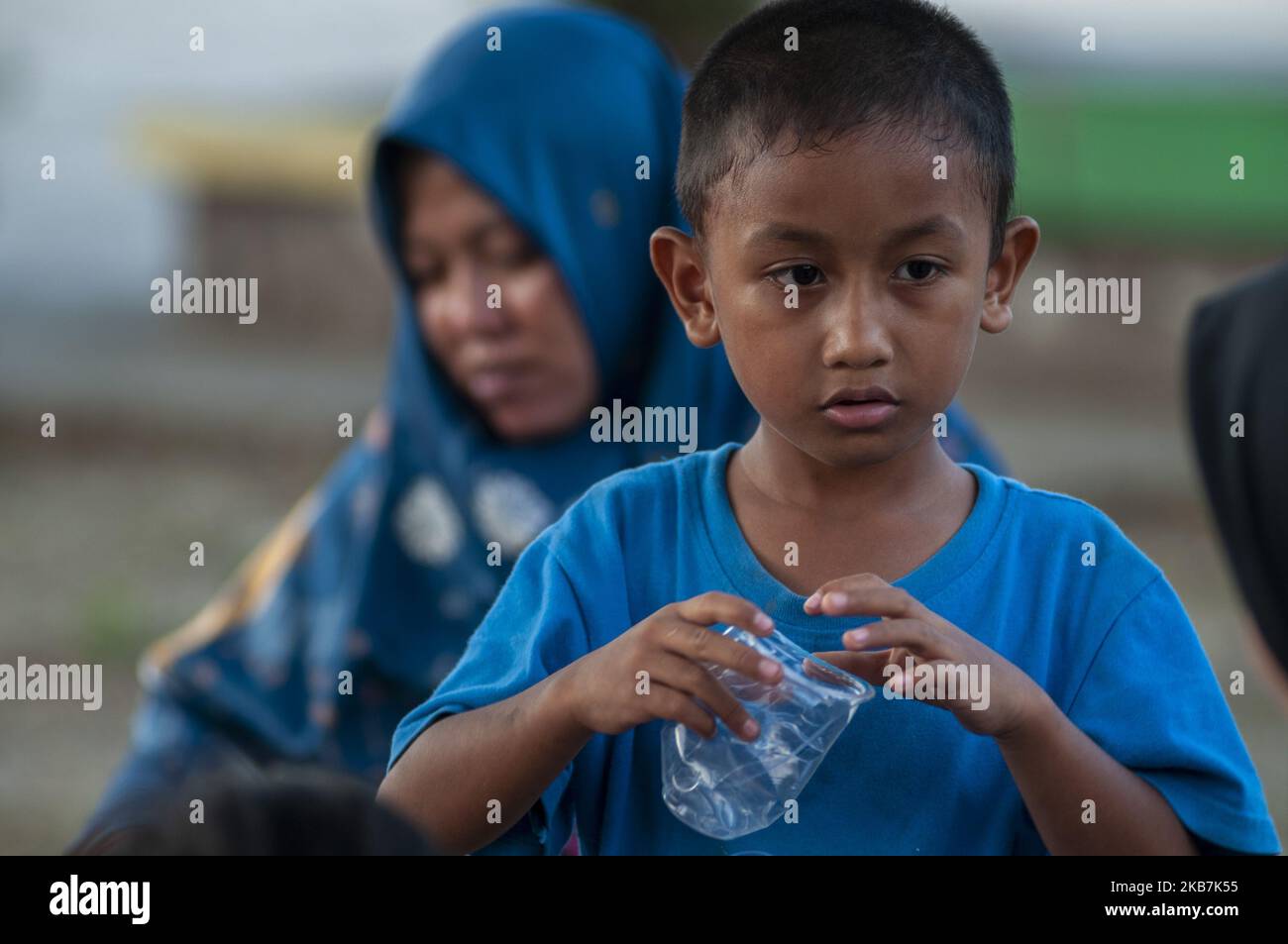 A child sorts out plastic waste to be put into bottles to be used as ...