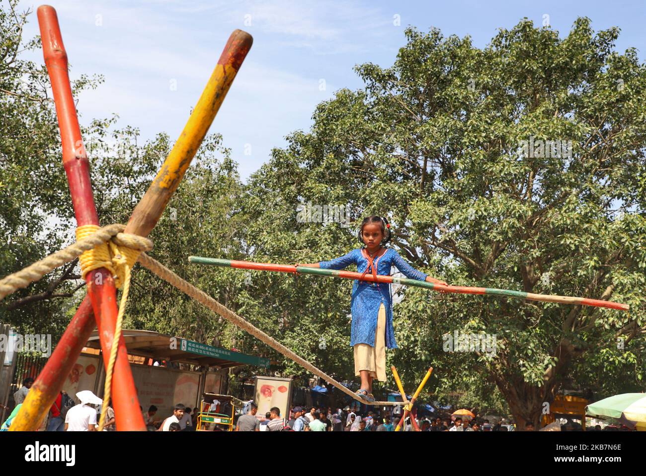 An indian performer on a tightrope during a street show in New Delhi ...