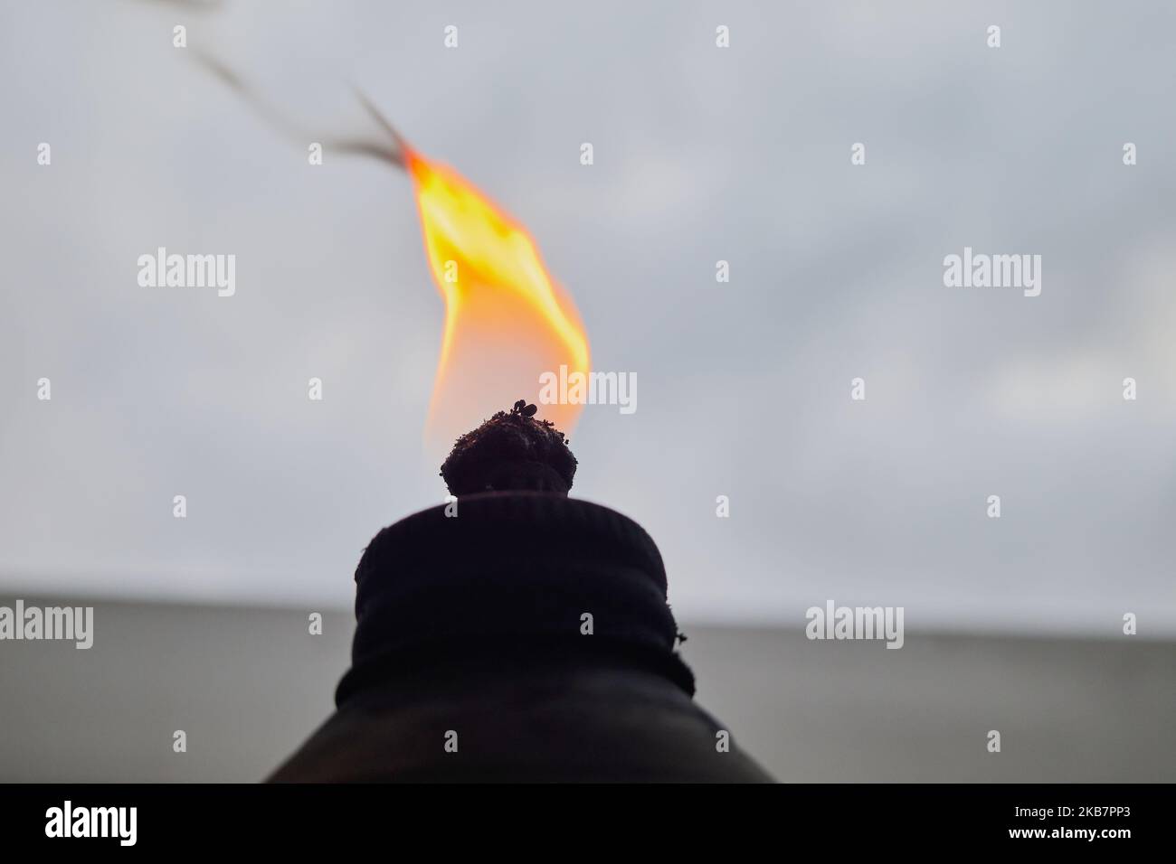 flame and burning wick on an oil torch against an overcast sky Stock ...