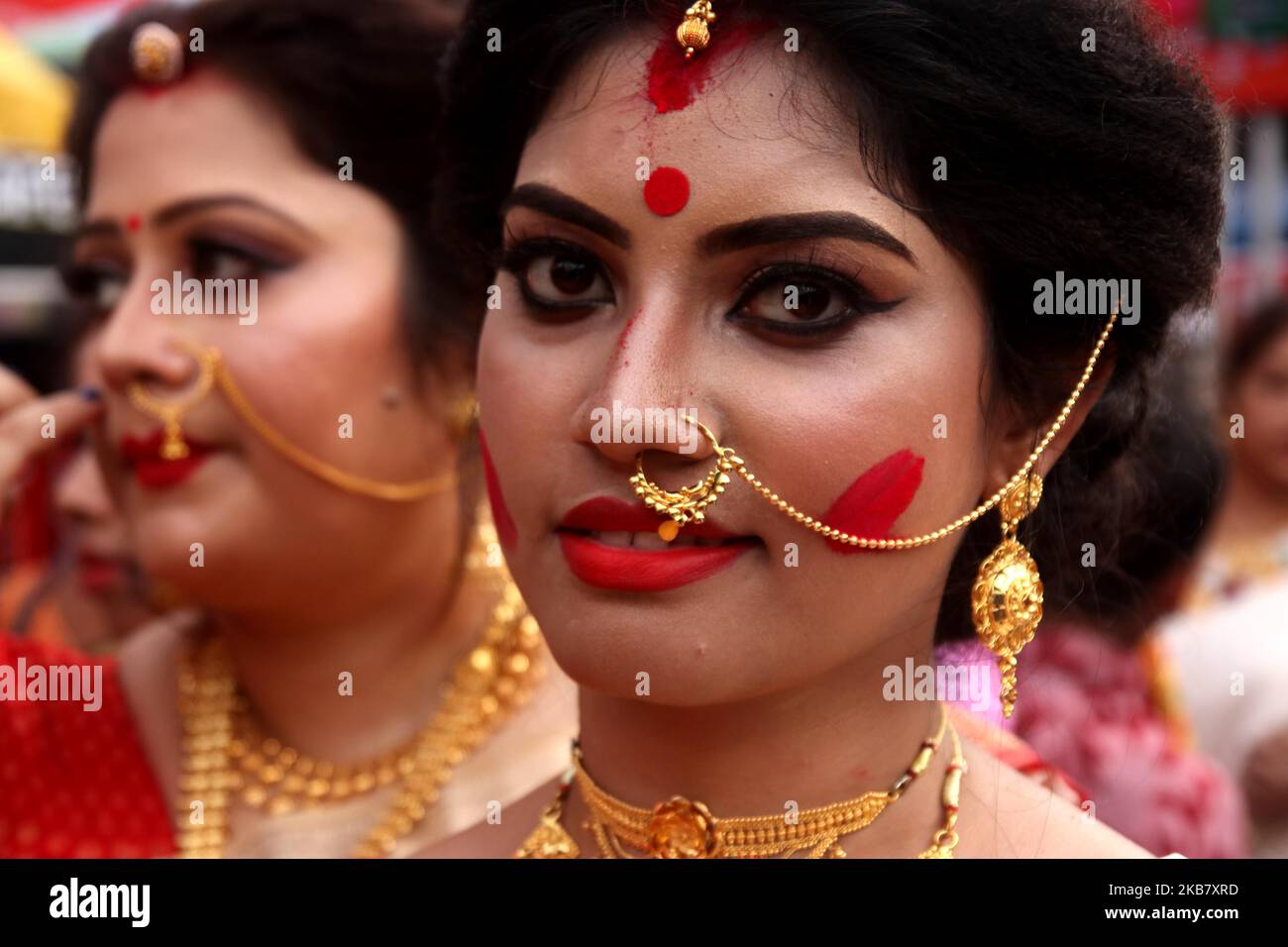An Indian Hindu devotee smiles as she is smeared with vermillion powder ...