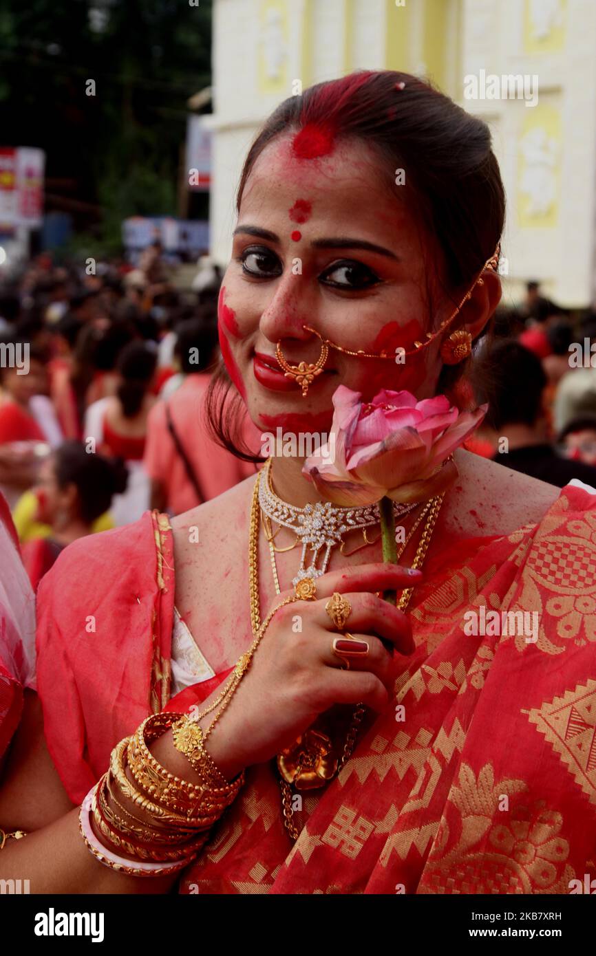 An Indian Hindu devotee smiles as she is smeared with vermillion powder ...