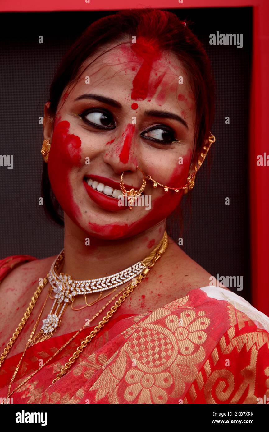 An Indian Hindu devotee smiles as she is smeared with vermillion powder ...